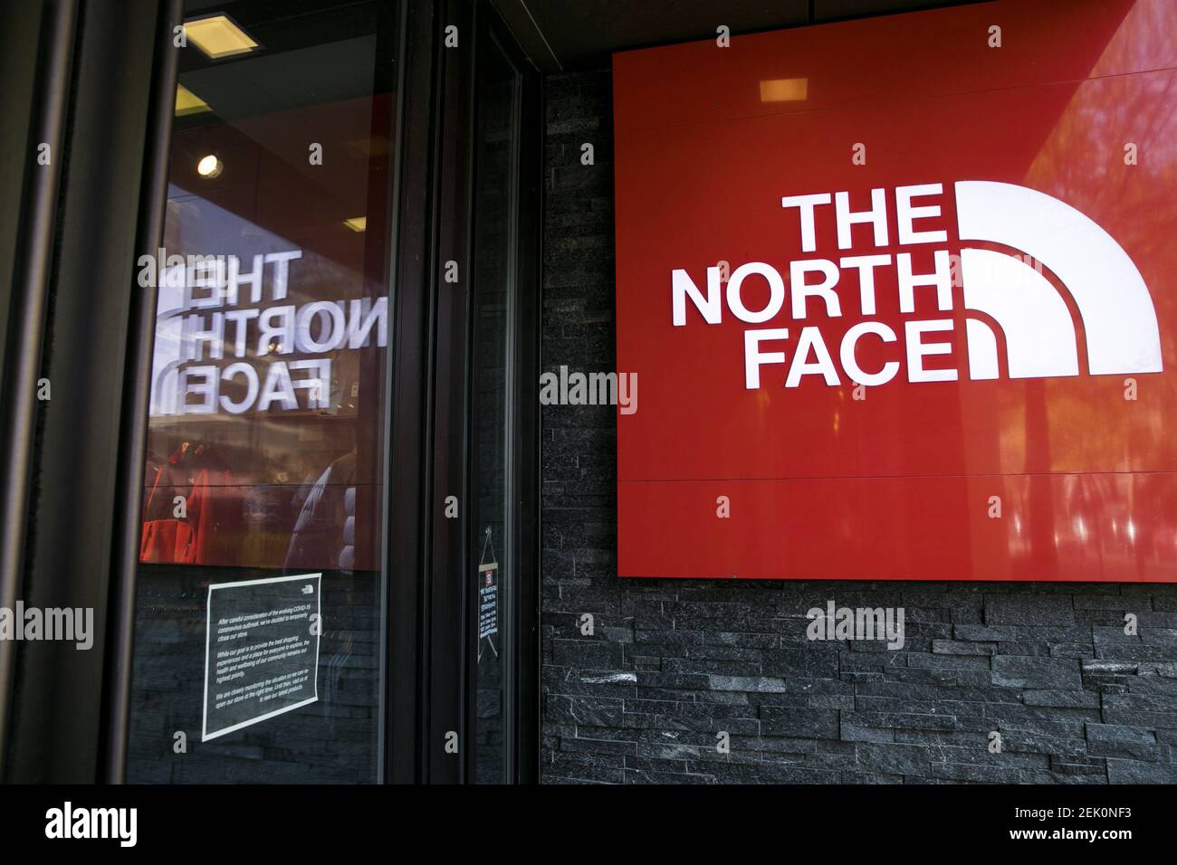A logo sign outside of a The North Face retail store location in ...