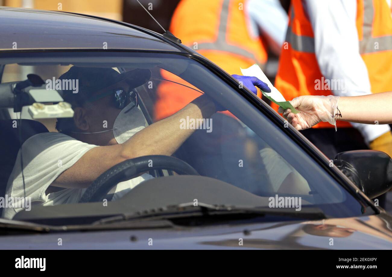 A Hialeah resident hands a ticket to a City of Hialeah employee during ...