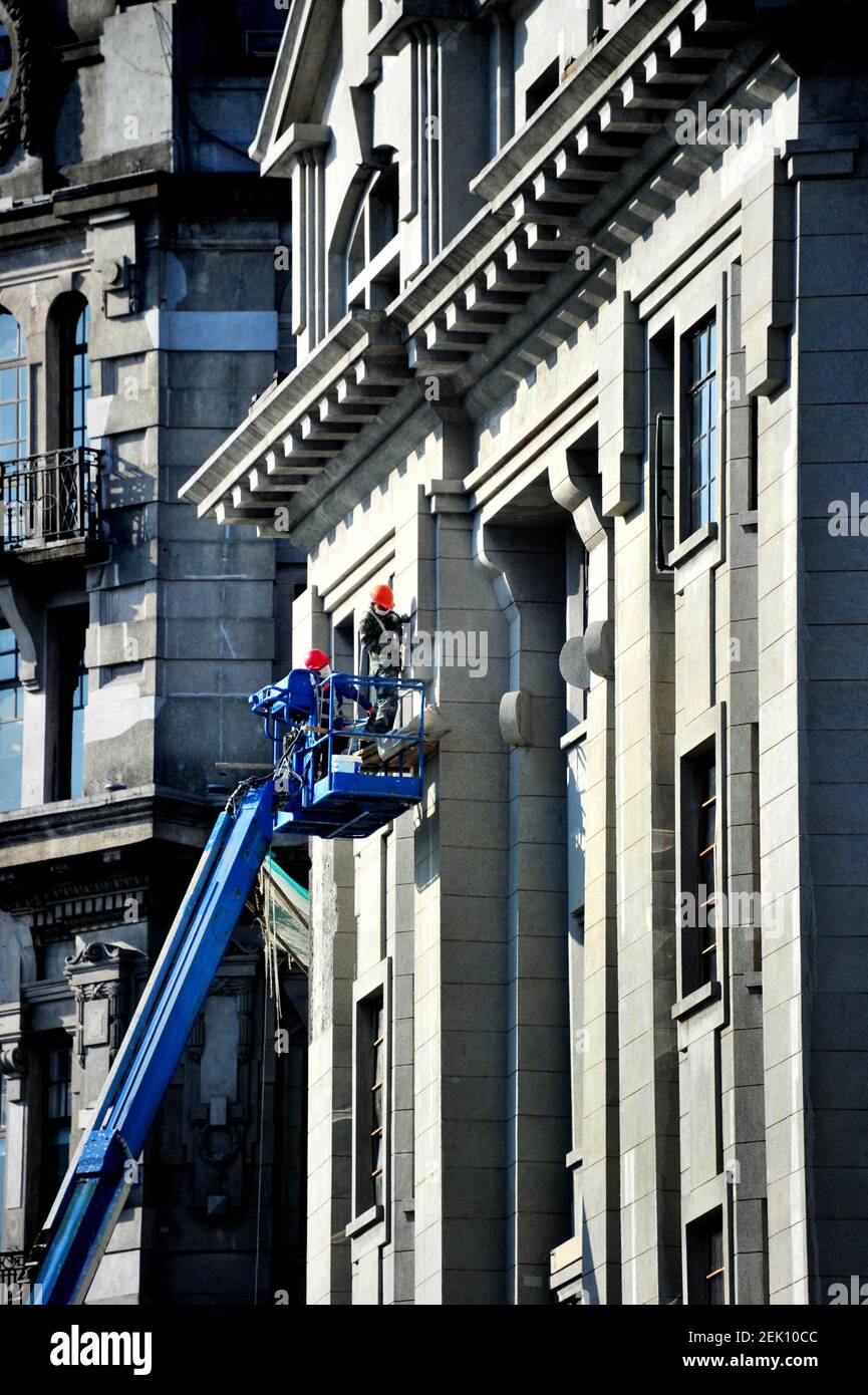 Workers are busy at renovating an old building, which belongs to the ...