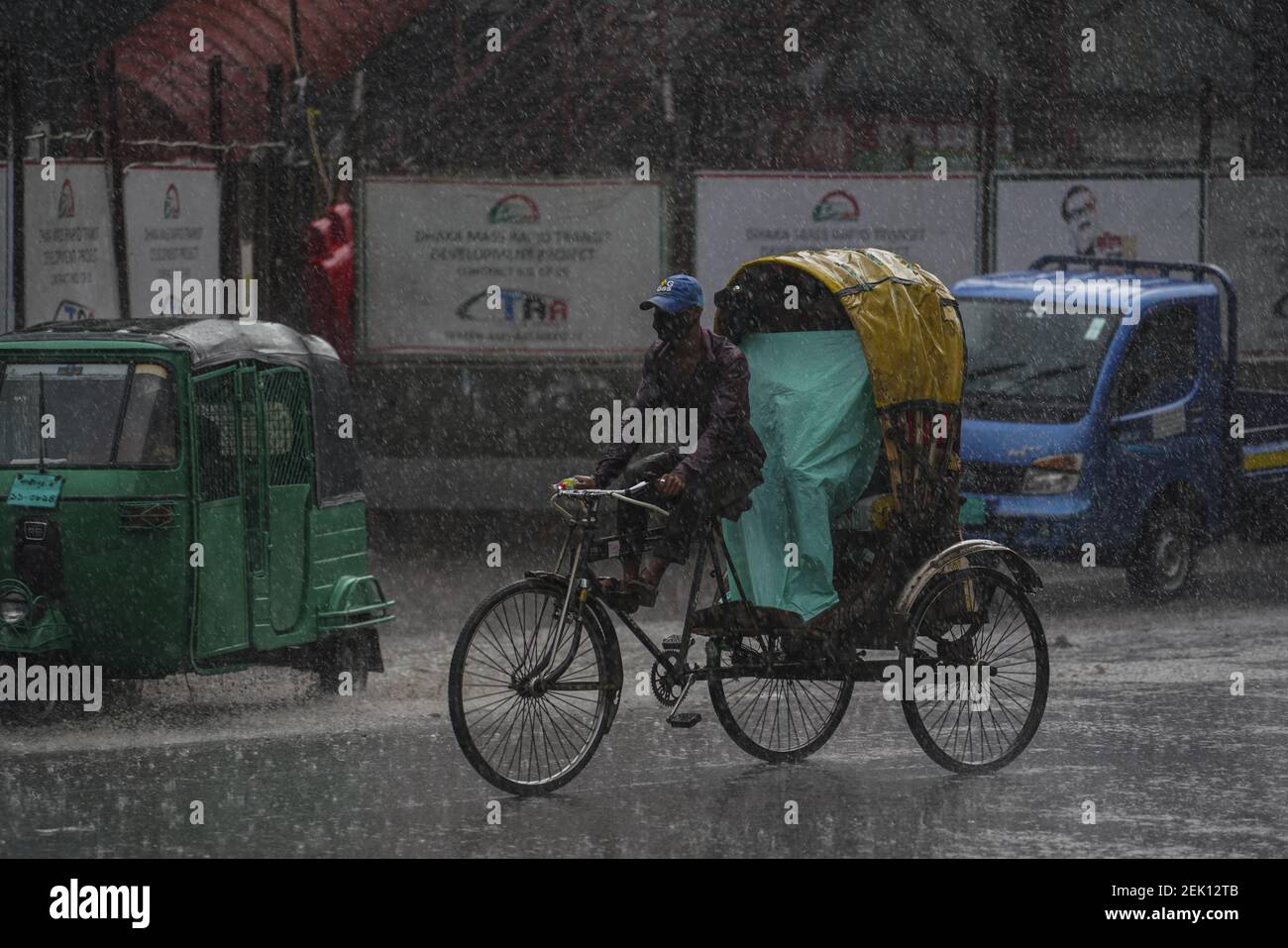 Rickshaw driver ride on rickshaw during heavy rainfall in Dhaka ...