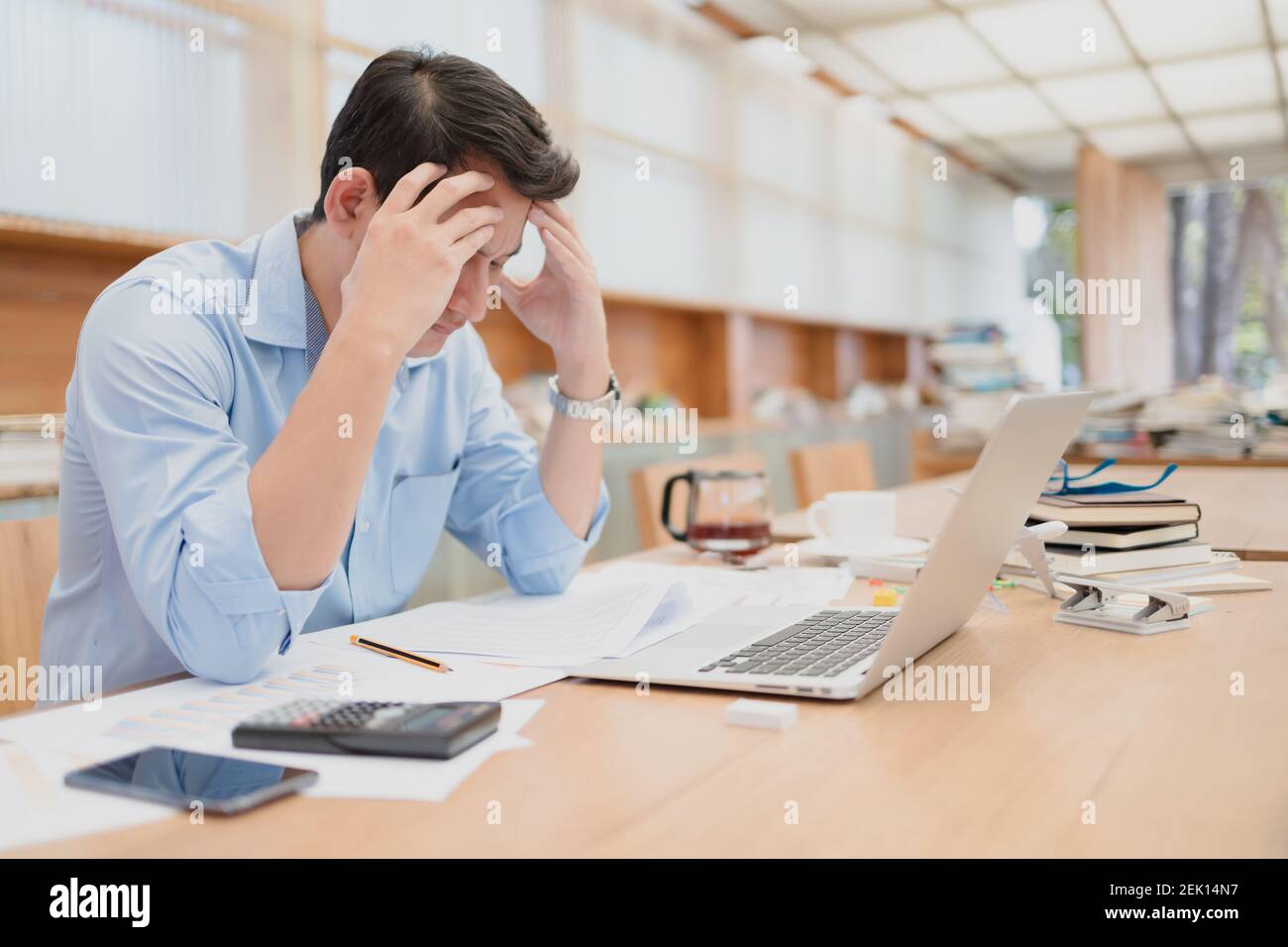Tired businessman at workplace in office holding his headache or angry ...