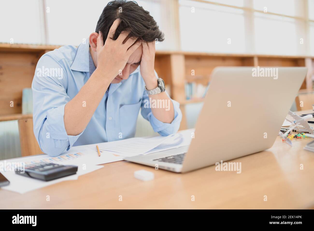 Tired businessman at workplace in office holding his headache or angry ...