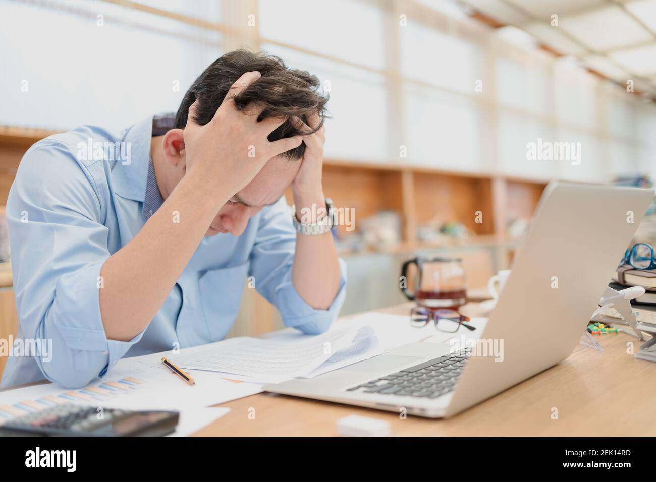 Tired businessman at workplace in office holding his headache or angry ...