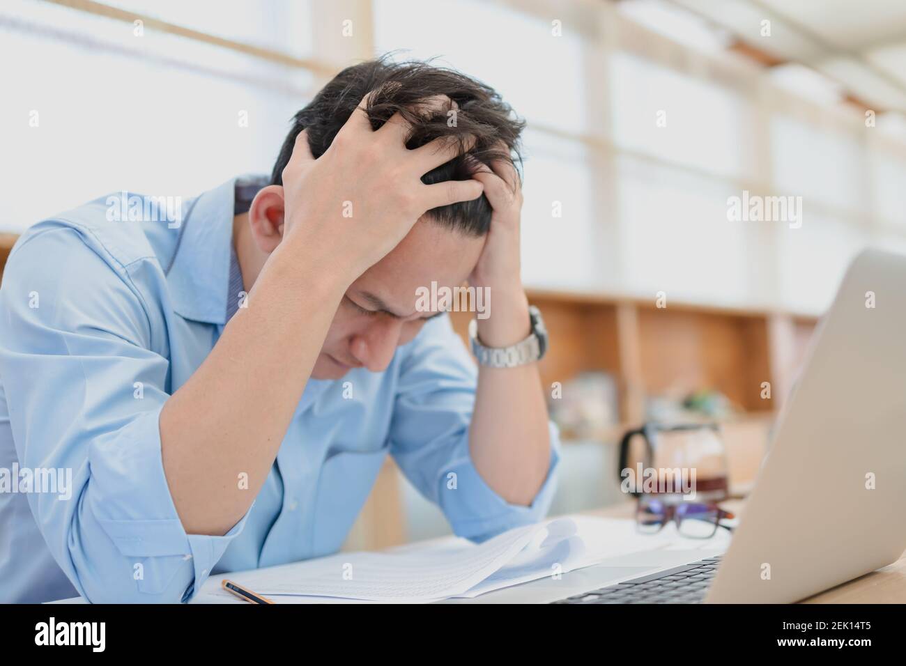 Tired businessman at workplace in office holding his headache or angry ...