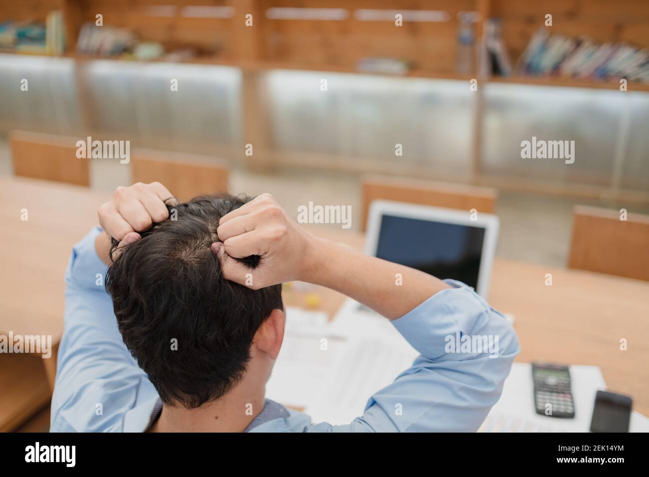 Tired businessman at workplace in office holding his headache or angry ...