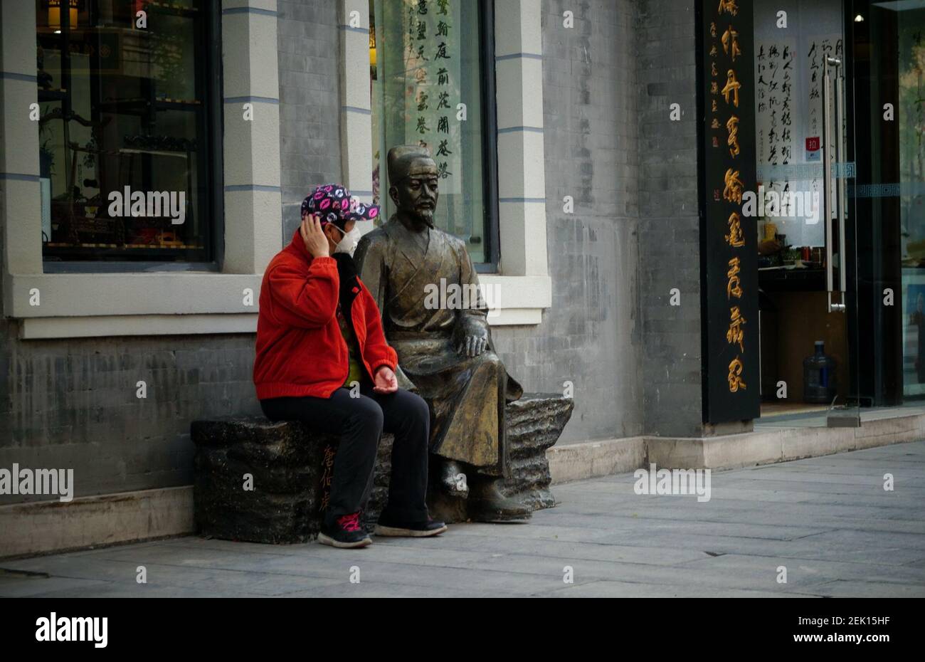 BEIJING, CHINA - APRIL 27, 2020 - A pedestrian and statue are made ...