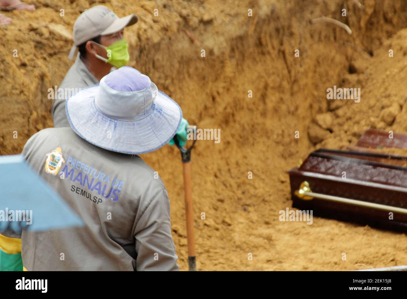 Gravediggers in a ditch with the coffins at the Parque de Manaus ...