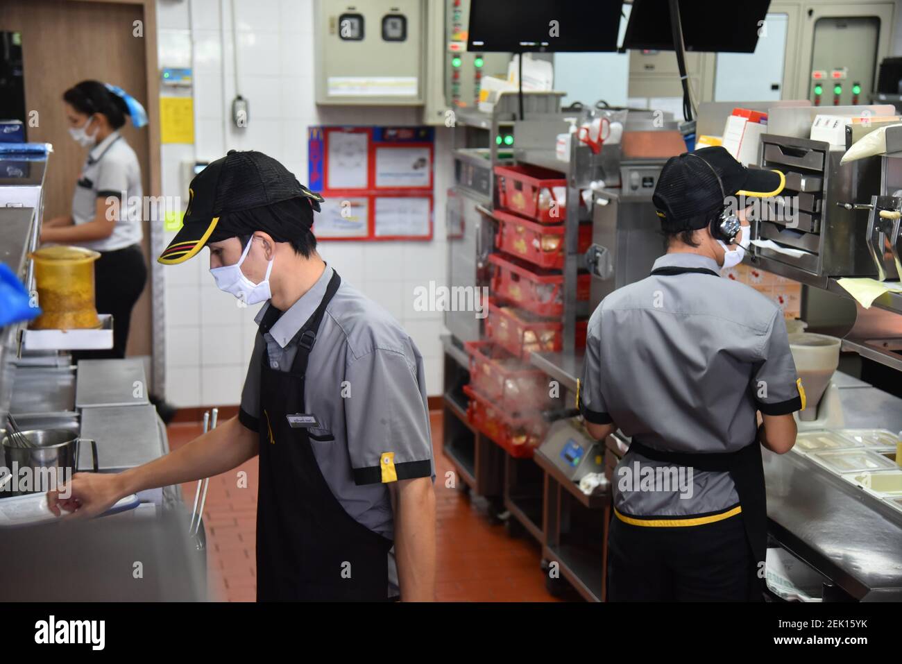 An employee of McDonald's wearing a protective mask as a precaution ...