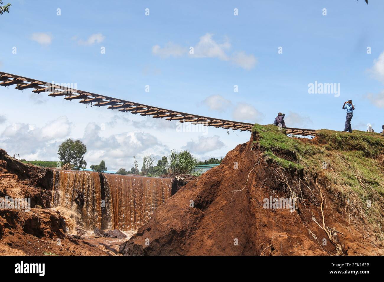 A policeman uses his phone to take pictures of a precariously suspended ...