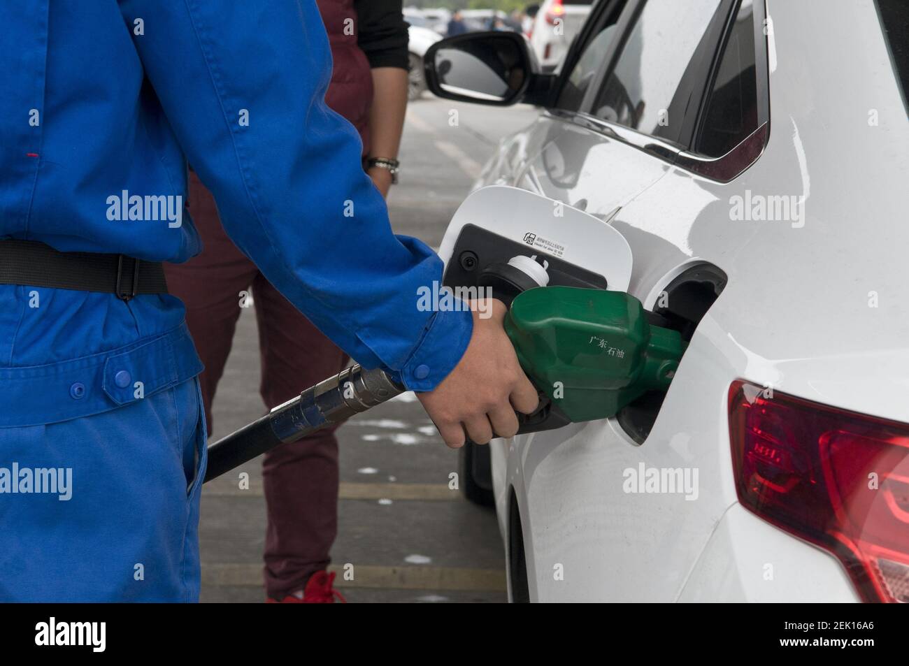 In this unlocated and undated photo, a staff works to add petrol to a ...