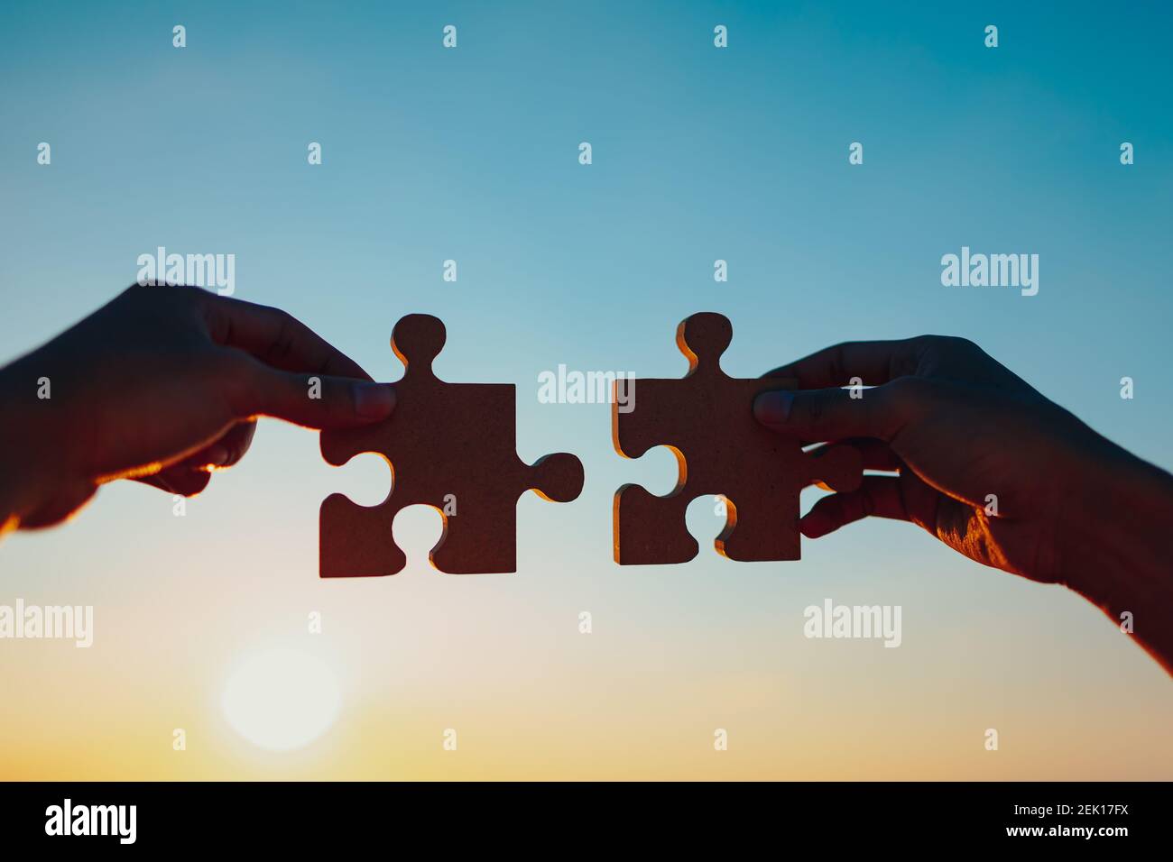 two hands of businessman to join jigsaw puzzle piece with sky ...