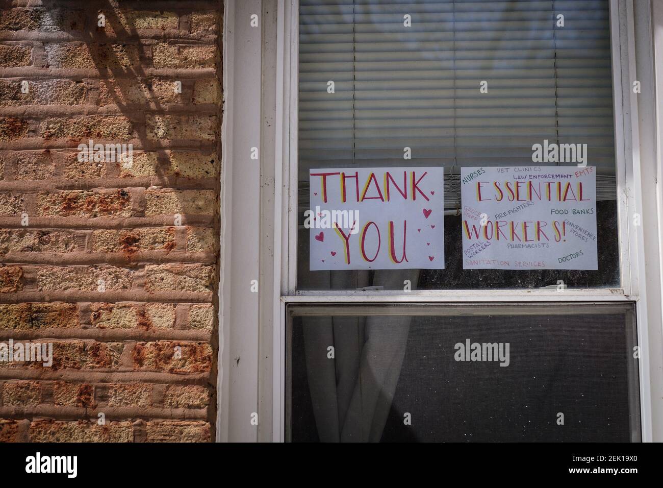 Signs in the window of a residence express thanks to essential workers ...
