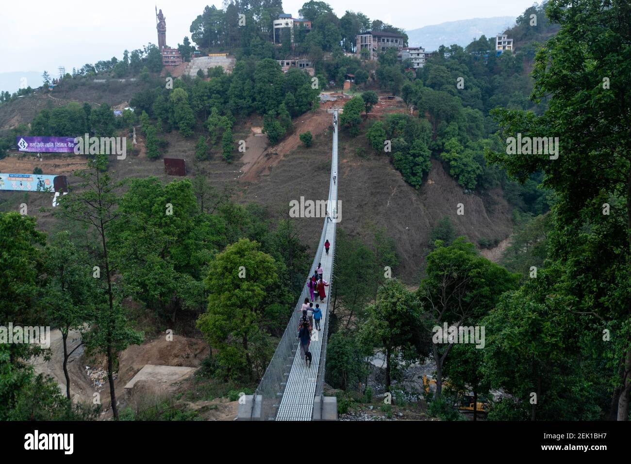 People are pictured on a suspension bridge that connects to two nearby ...