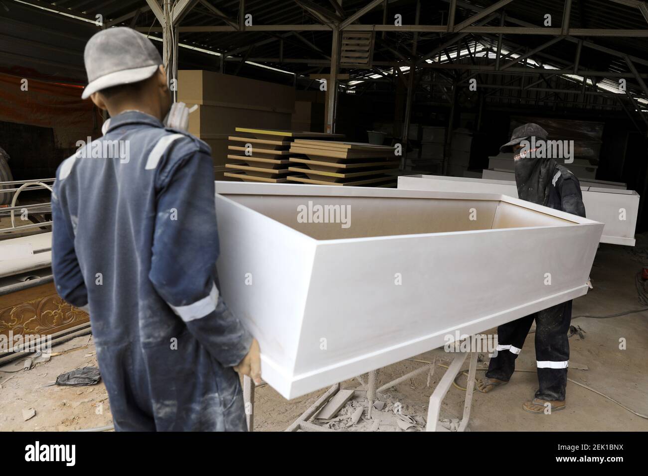 Coffin makers working on special coffins coated with plastic to prevent ...