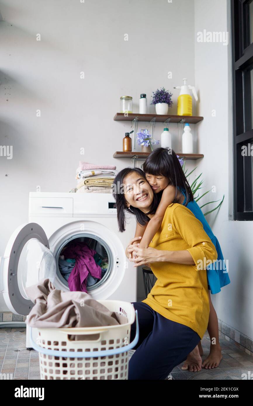 Beautiful young asian woman and child girl little helper are doing laundry at home Stock Photo ...
