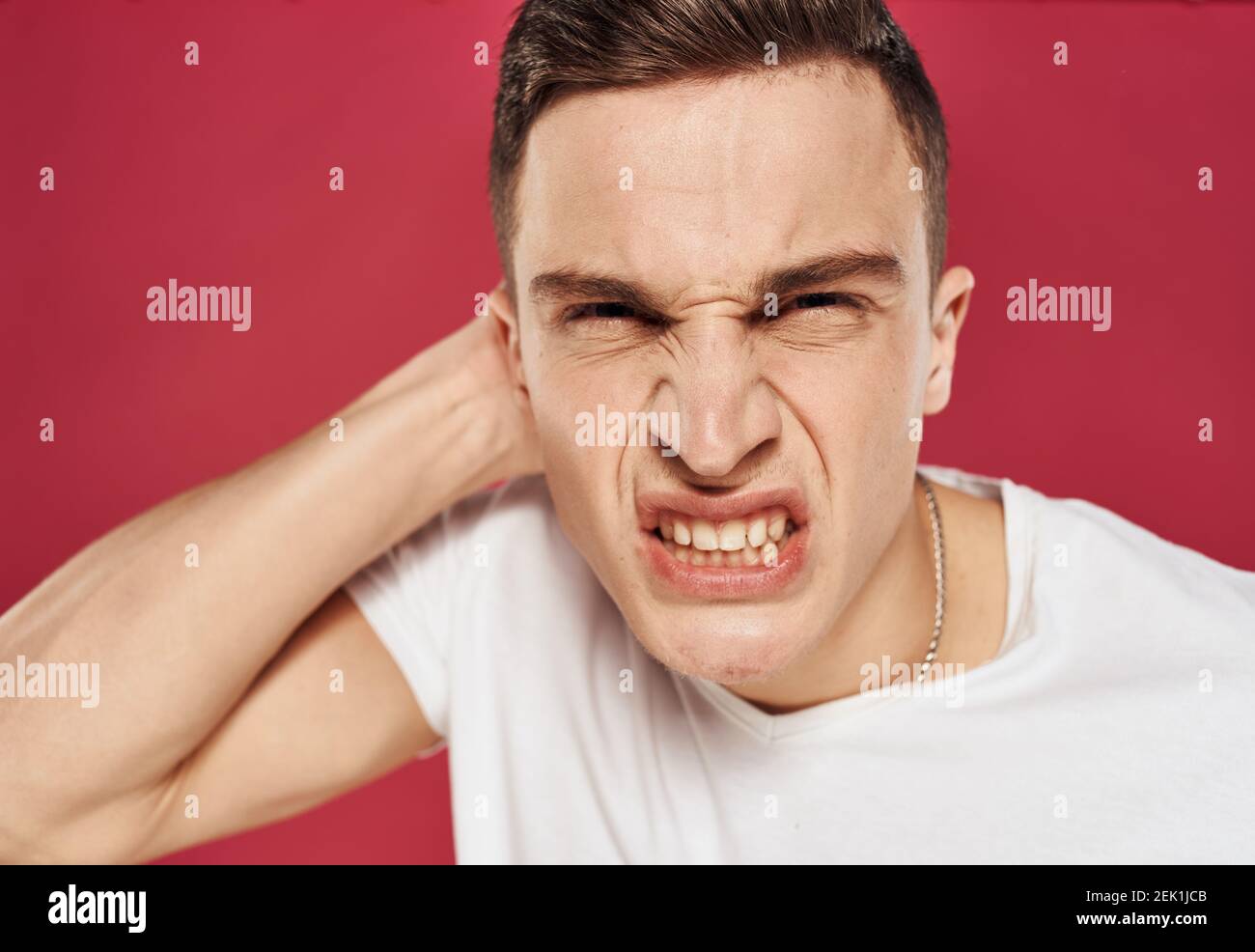 angry man displeased facial expression close up emotion red background ...