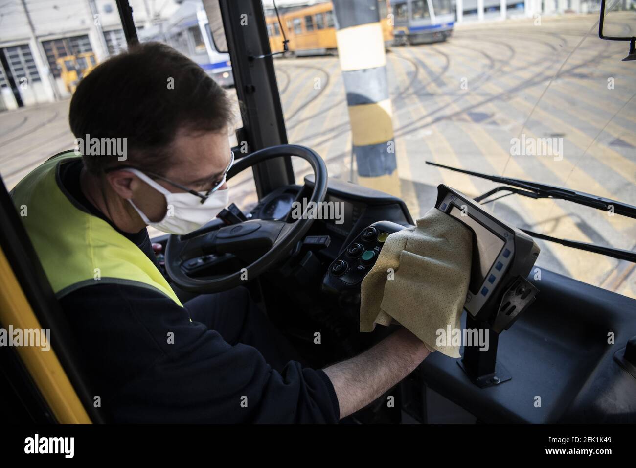 A technician, wearing protective mask, cleaning bus and tram during ...