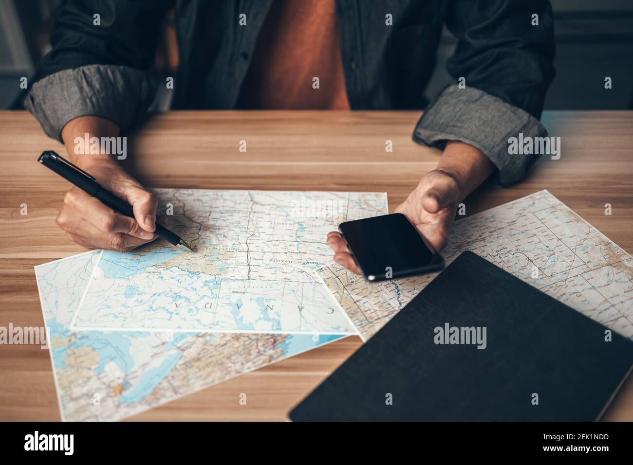 Tourist use pen for marking location and planing travel. Map and book ...