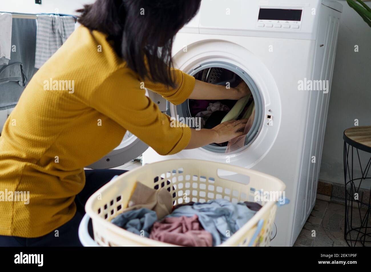 close up of woman in front of the washing machine doing some laundry ...