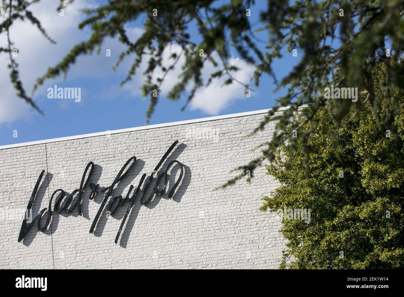 A logo sign outside of a Lord & Taylor department store location in ...