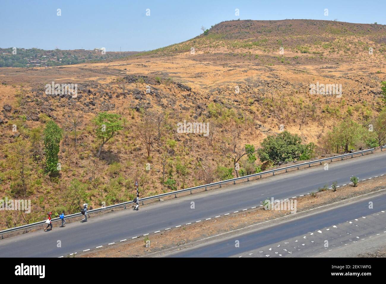 Migrant workers walk along a deserted road during the Coronavirus ...