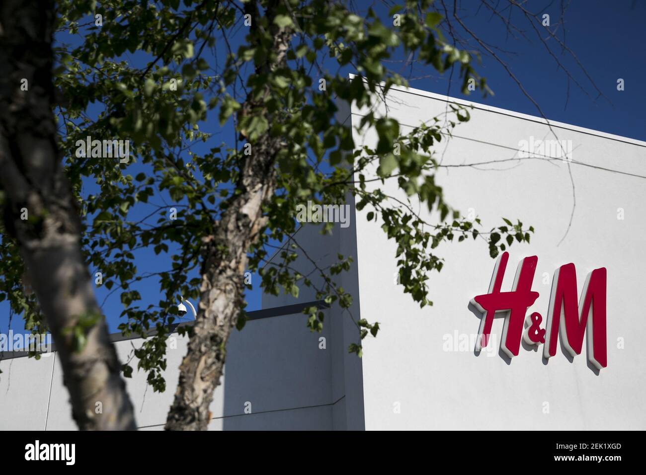 A logo sign outside of a Hennes & Mauritz (H&M) retail store location ...
