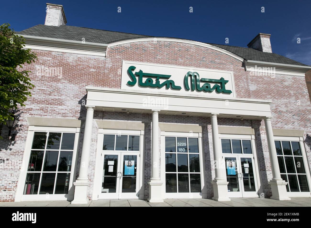 A logo sign outside of a Stein Mart retail store location in ...
