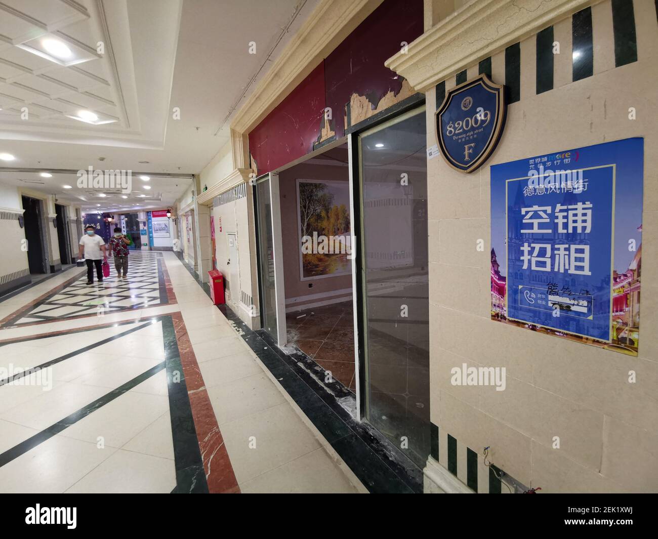 A shop puts up a poster for transfer at Guanggu Pedestrian Street in ...