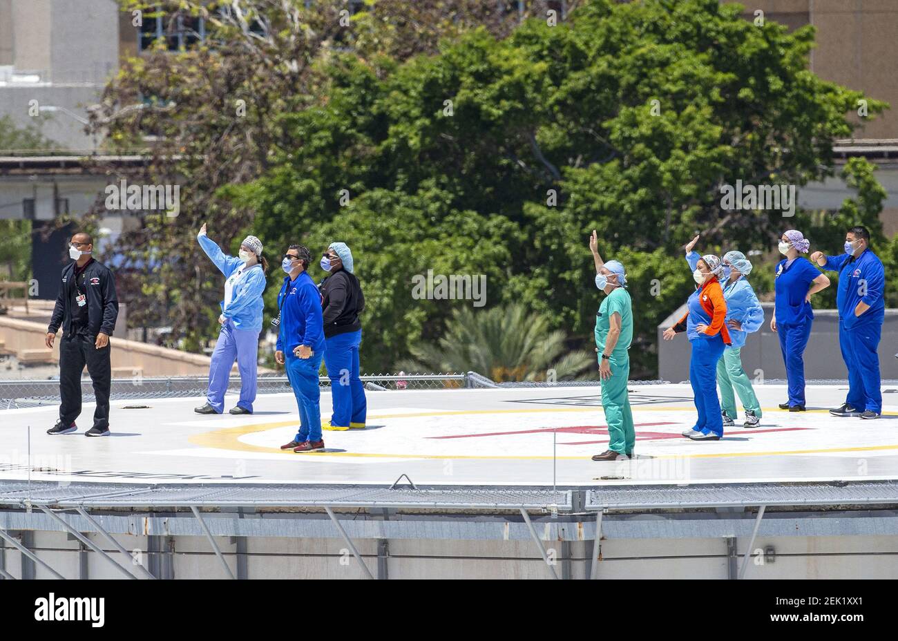 Healthcare workers watch from a rooftop at Jackson Memorial Hospital in ...