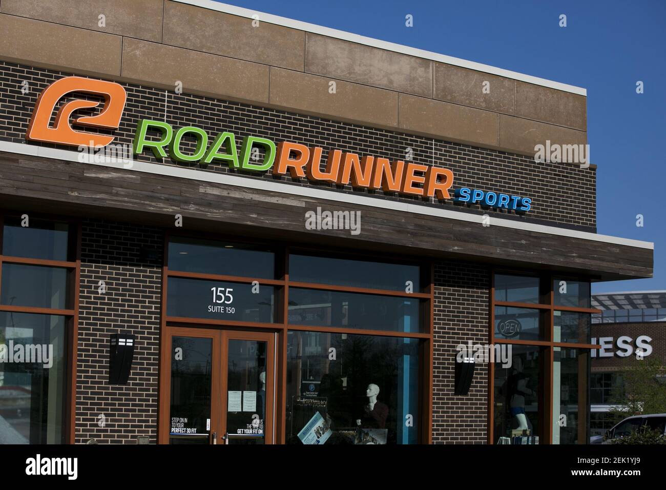 A logo sign outside of a Road Runner Sports retail store location in ...