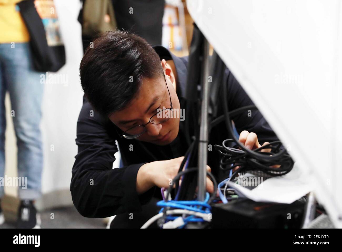 A person checks on one of the cleaning robots from Gaussian Robotics at ...