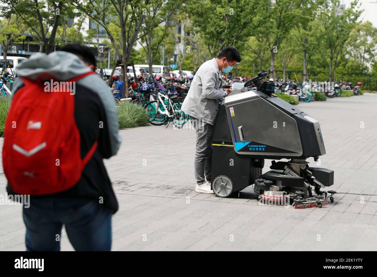 A person checks on one of the cleaning robots from Gaussian Robotics at ...