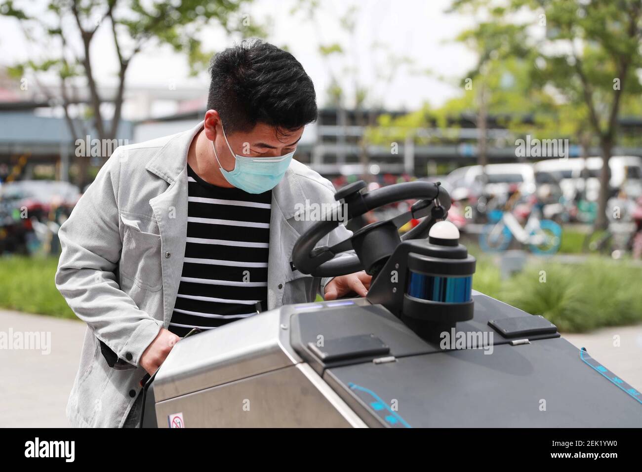 A person checks on one of the cleaning robots from Gaussian Robotics at ...