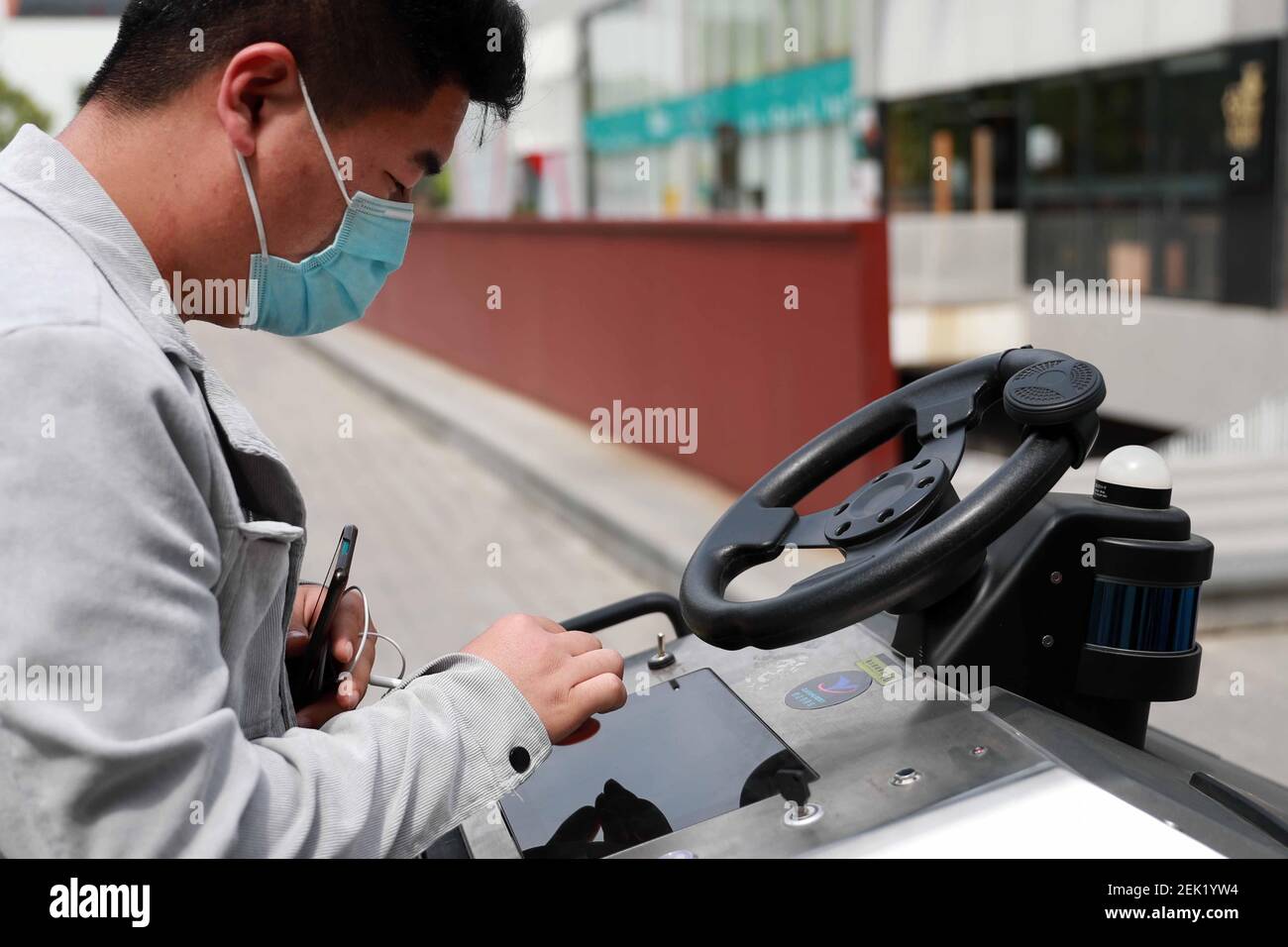 A person checks on one of the cleaning robots from Gaussian Robotics at ...