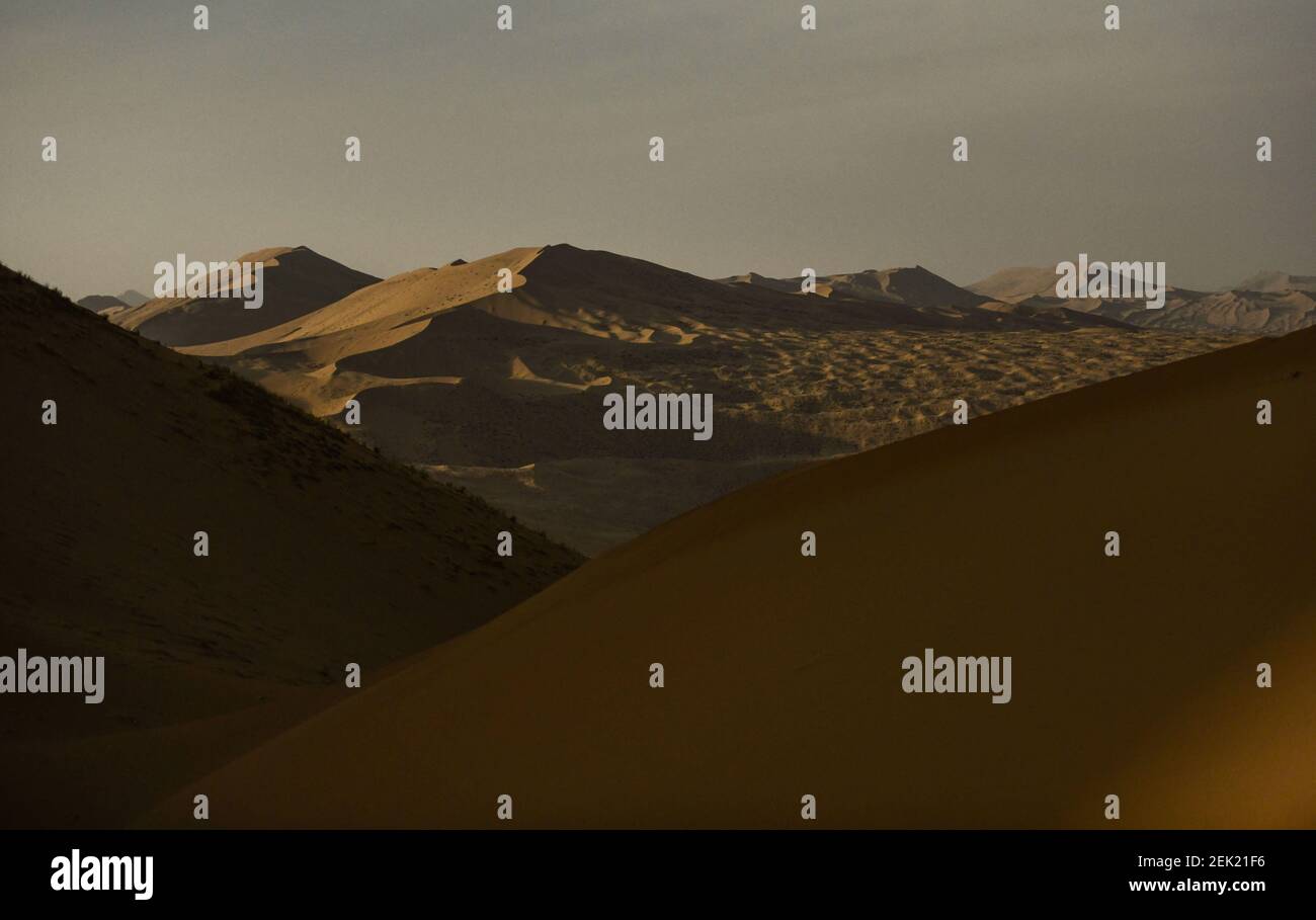 An aerial view of sunshine of the setting sun on the sand hills in the ...