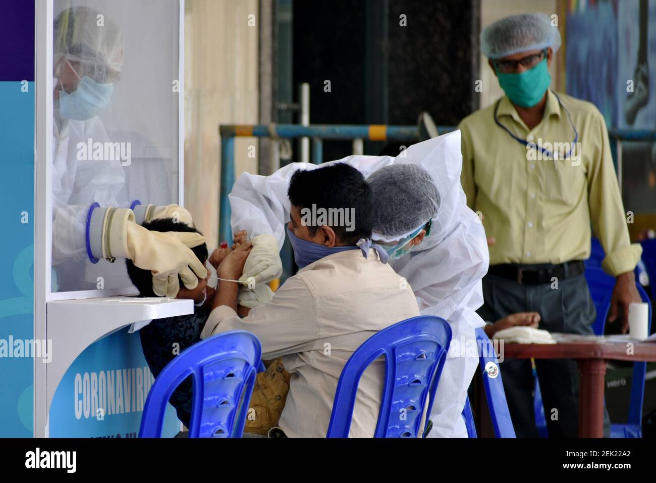People line-up and take swab tests at a Covid-19 testing site in Howrah ...