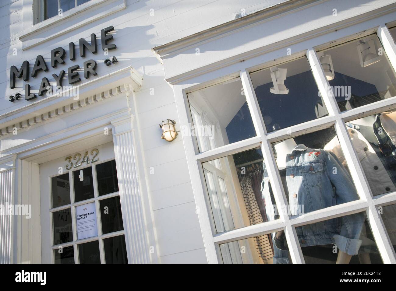 A logo sign outside of a Marine Layer retail store location in ...