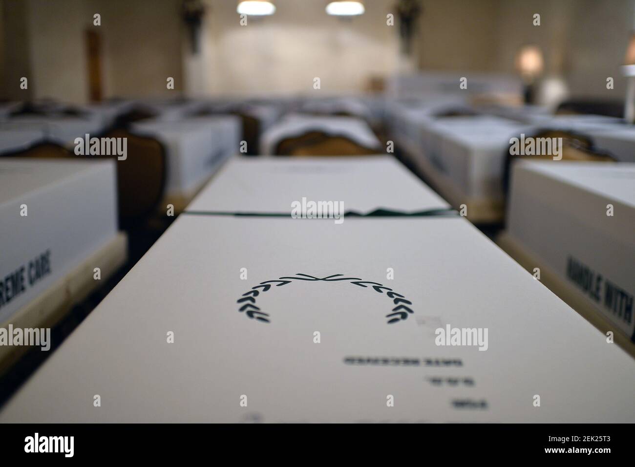 Bodies in cremation funeral caskets are lined up in rows sitting on ...