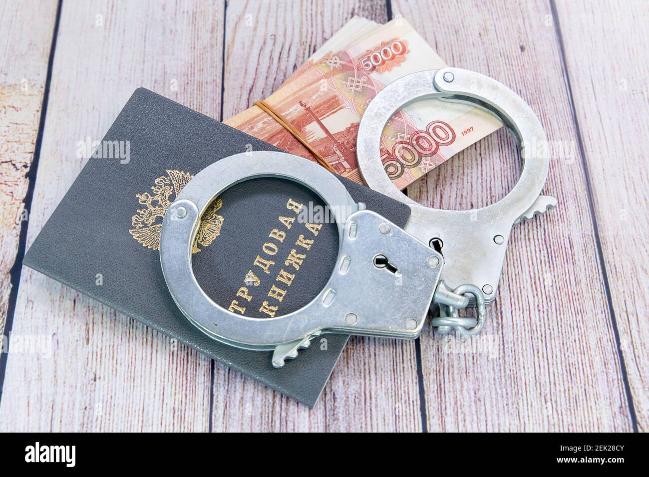 Labor book, handcuffs and money. Responsibility for violation of labor ...