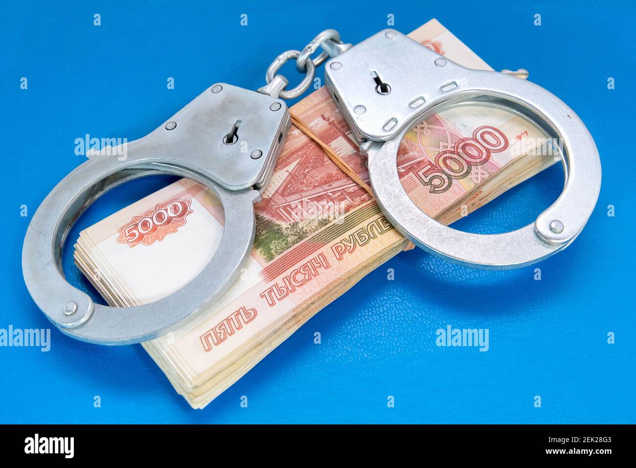 Handcuffs and money. Criminal penalty for fraud Stock Photo - Alamy