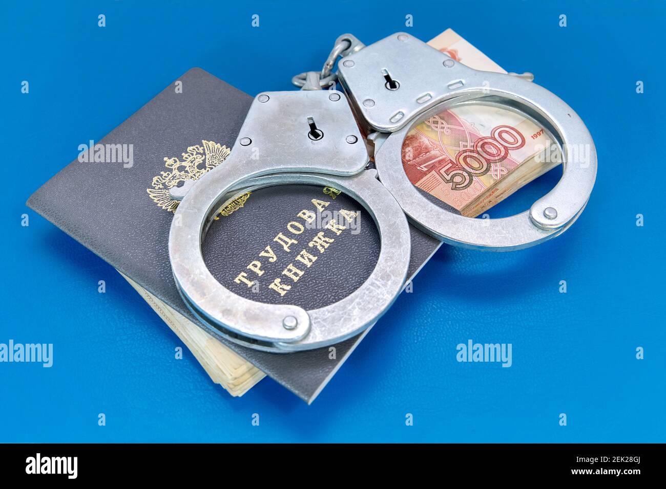 Labor book, handcuffs and money. Responsibility for violation of labor ...