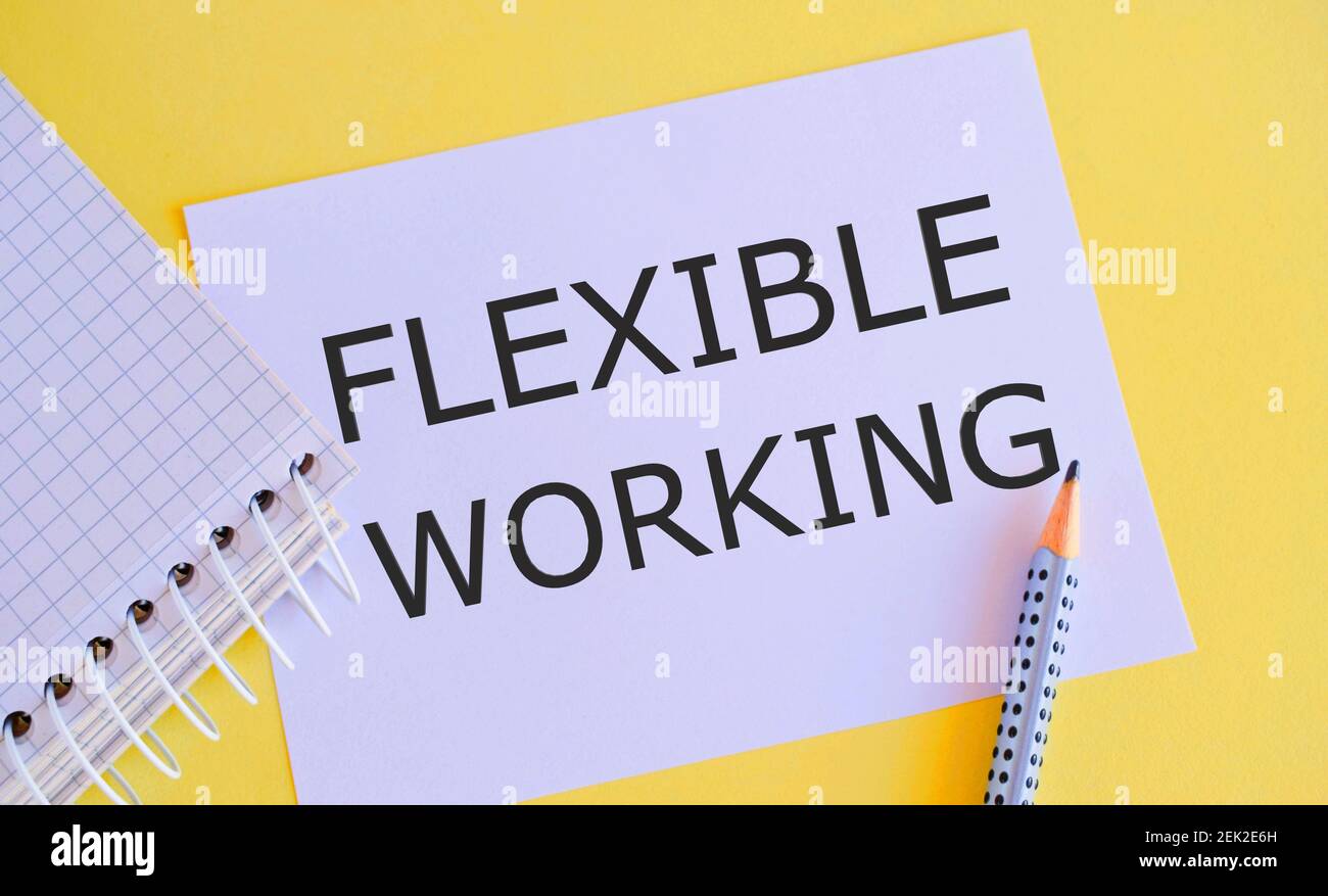 FLEXIBLE WORKING text written on white paper on yellow background ...