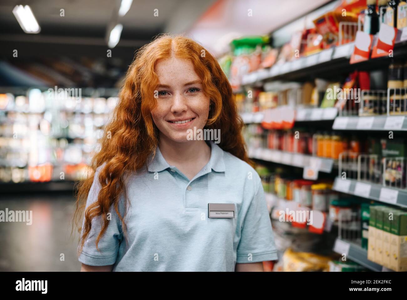 Female trainee in a supermarket. Woman working in a grocery store ...