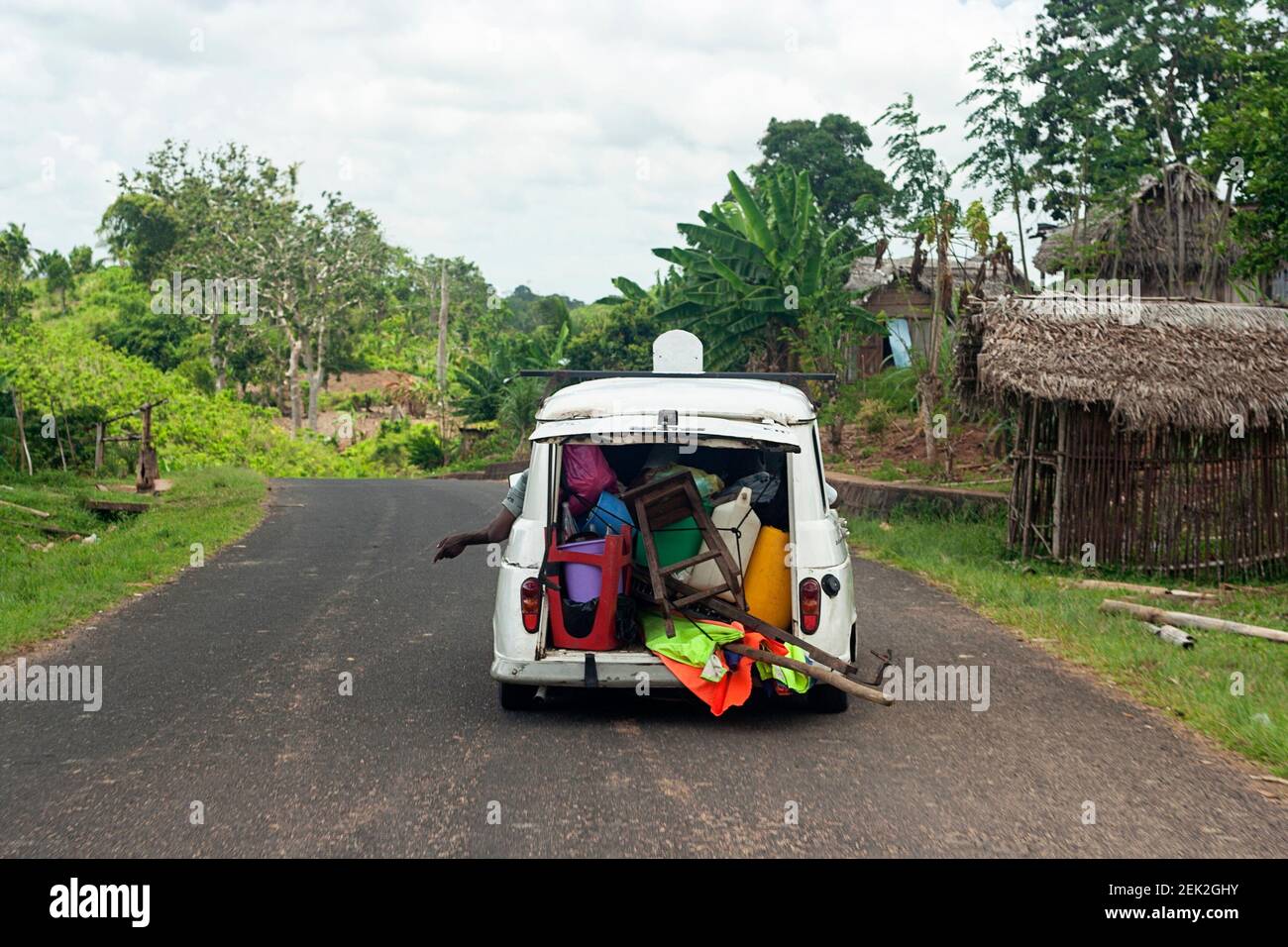 Old Renault 4 with fully loaded open trunk driving on a rural road in ...