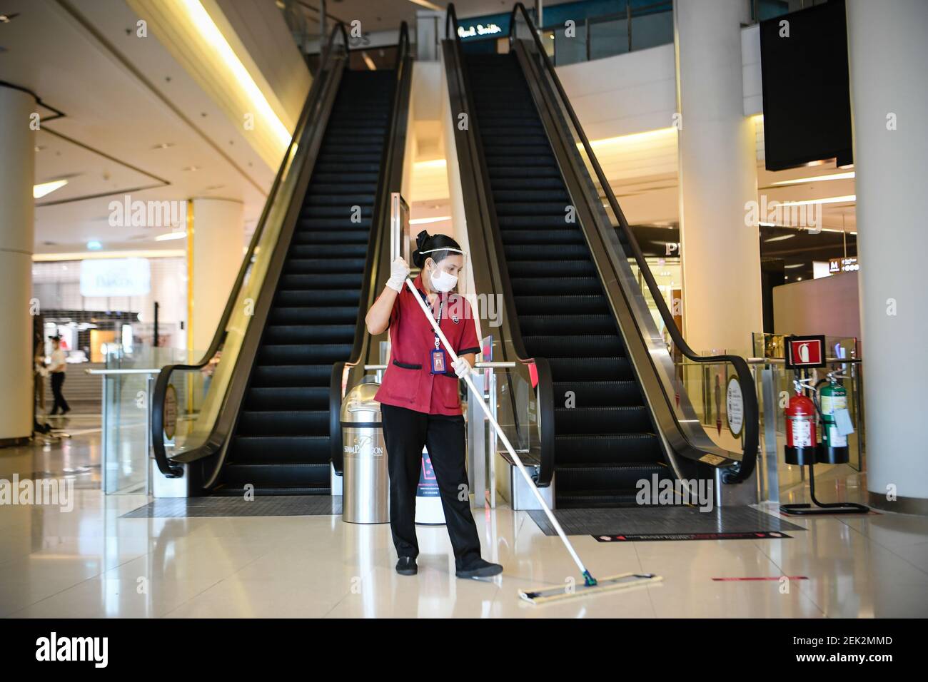 A worker wearing a face shield as a preventive measure seen cleaning ...