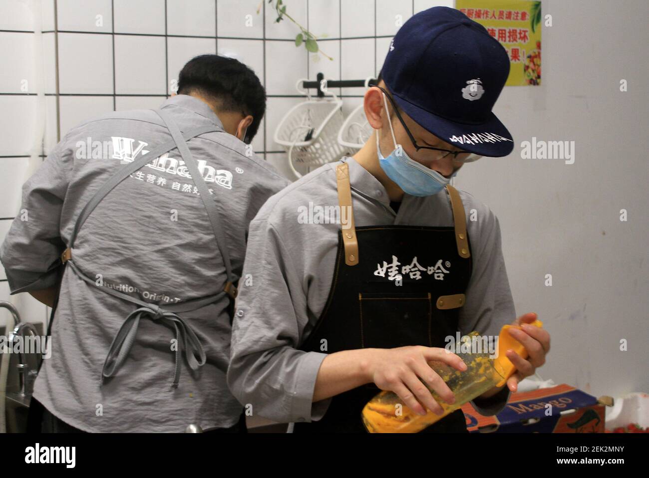 A staff of Wahaha prepares milk tea ingredients at a Wahaha milk tea ...