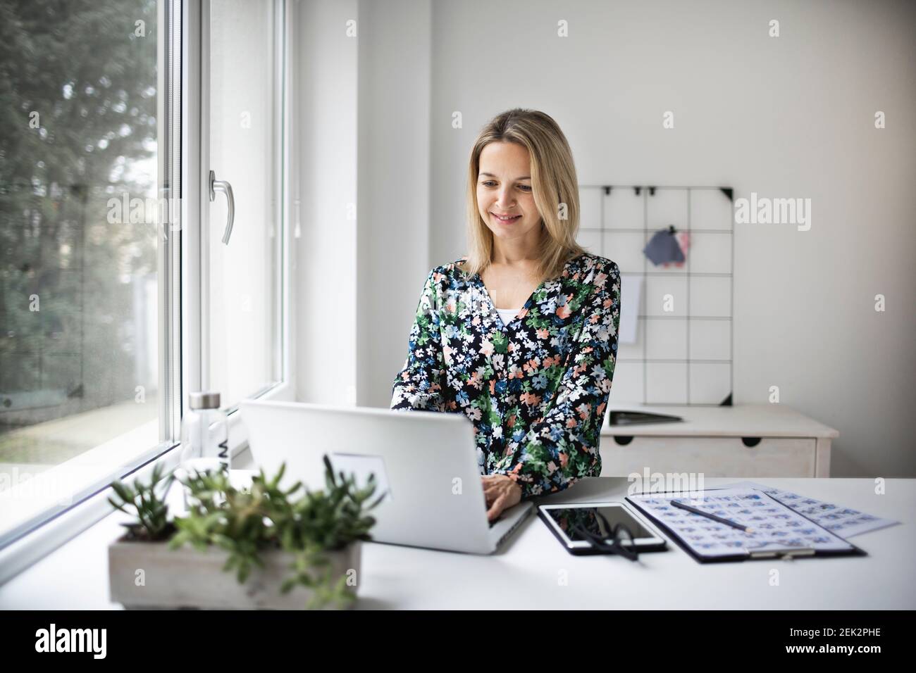 Businesswoman working at ergonomic standing workstation Stock Photo - Alamy