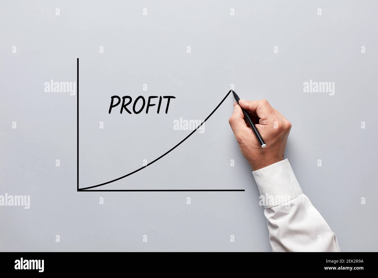 Male hand drawing a profit chart on gray background. Increasing profit ...