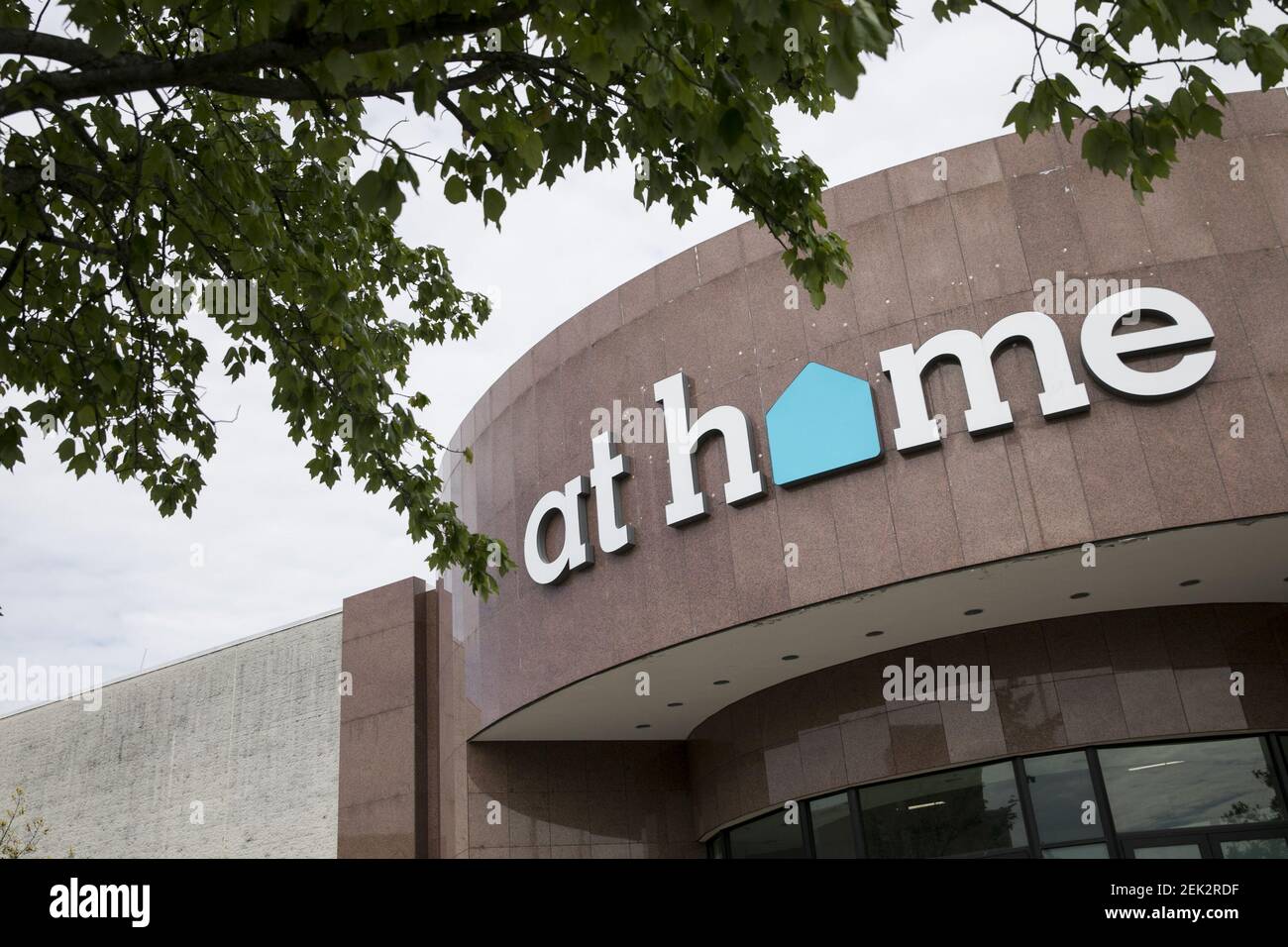 A logo sign outside of a At Home retail store location in Richmond ...