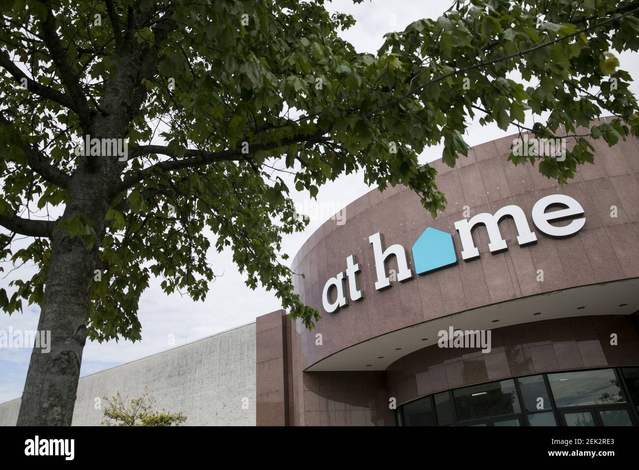 A logo sign outside of a At Home retail store location in Richmond ...